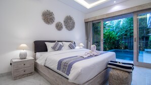 Quarto moderno com uma cama grande, mesas de cabeceira, arte decorativa na parede e vista para uma piscina.