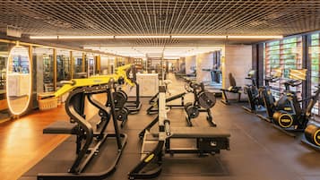 Uma academia com diversos equipamentos de exercício, incluindo máquinas de peso e esteiras.
