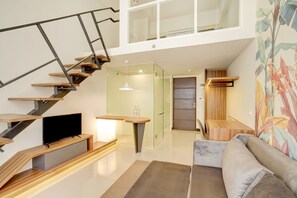 Um espaço de estar moderno com escada, televisão de tela plana, sofá e porta de vidro que dá para outro ambiente.