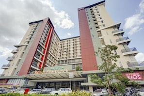 Um edifício de vários andares com uma placa de destaque para 'AMEGA Crown Residence'.