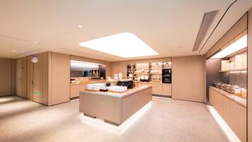 Cozinha de hotel moderna com ilha central, eletrodomésticos embutidos e design limpo e minimalista.
