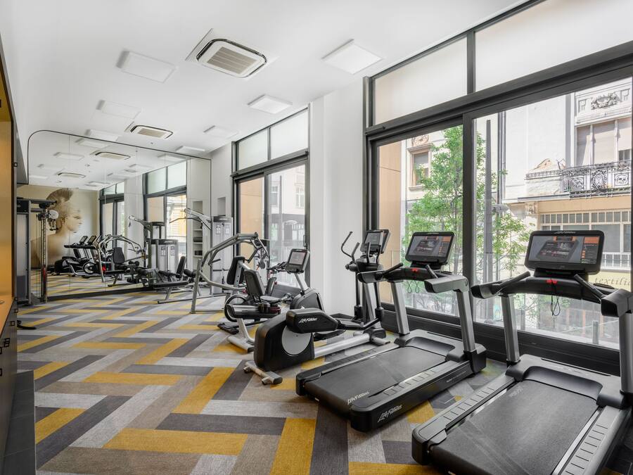 Academia com esteiras, elípticos e equipamentos de musculação.