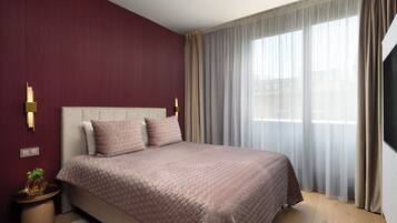 Quarto com cama, cortinas e luminária fixada na parede.