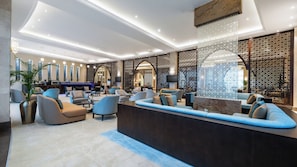 Um lobby moderno com balcão de recepção, área de estar e painéis decorativos.