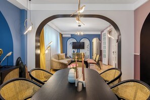 Uma área de refeições com uma mesa comprida, cadeiras e um objeto decorativo central.