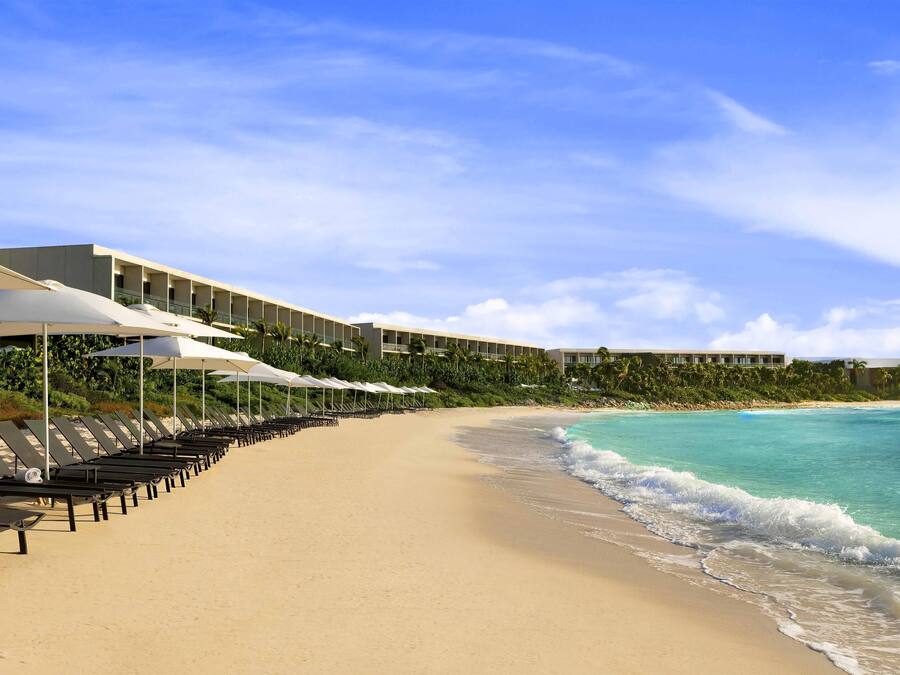 Na praia, praia de areia branca, espreguiçadeiras, guarda-sóis de praia