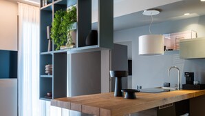 Uma cozinha moderna com ilha de madeira, prateleiras embutidas e luminária pendente.