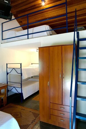 Quarto com beliche, guarda-roupa e escada.