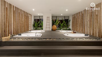 Uma área de spa com duas banheiras de hidromassagem, uma escada e um vaso grande.