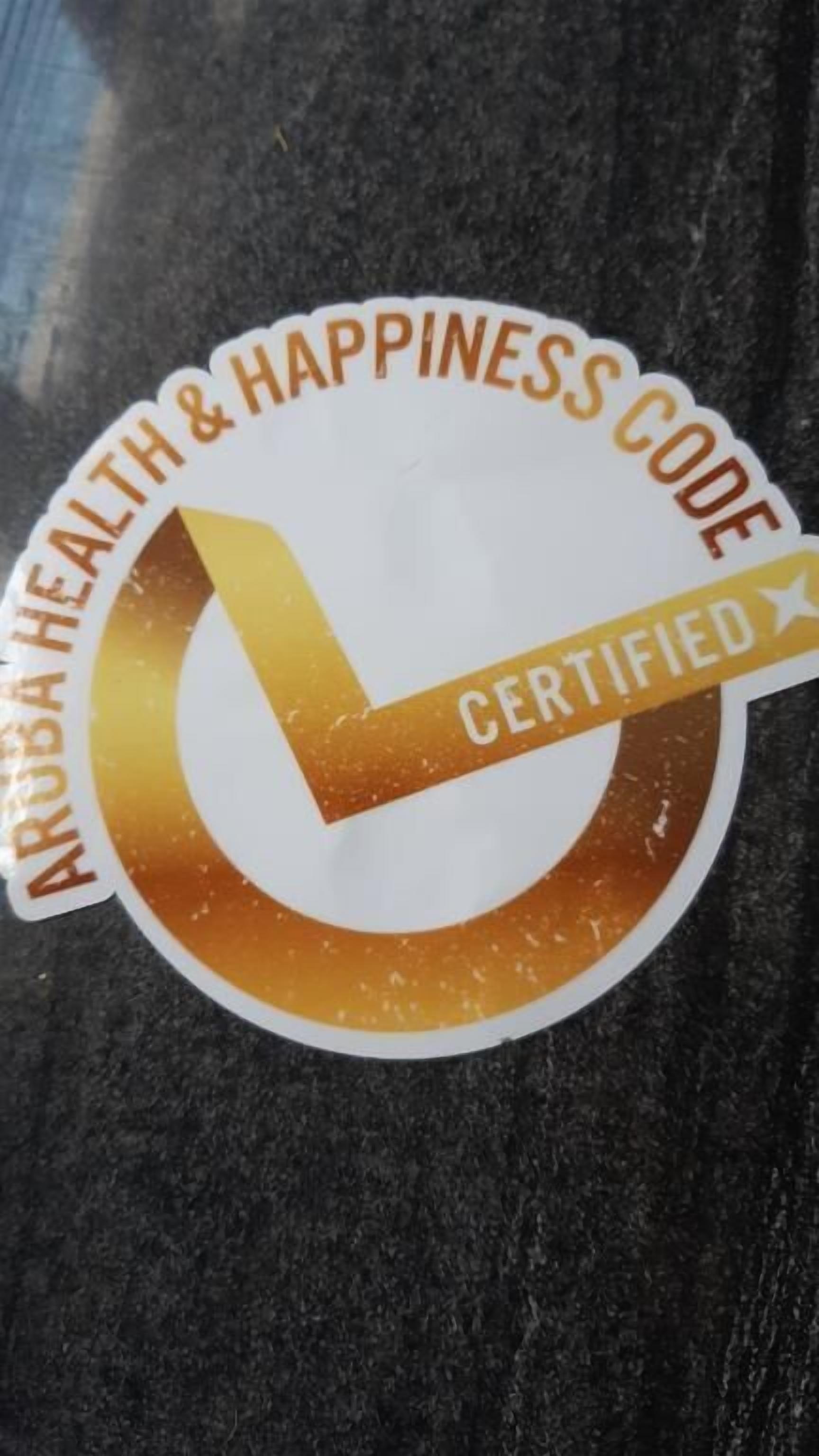 Um adesivo com o texto 'Aruba Health & Happiness Code Certified'.