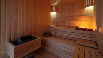 Uma sauna com bancos de madeira, um aquecedor para os bancos e um banco de madeira com uma toalha.