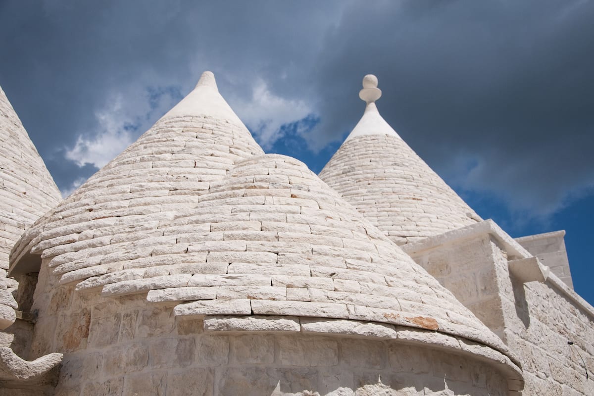 Um edifício com telhados brancos em forma de cone e um céu limpo.