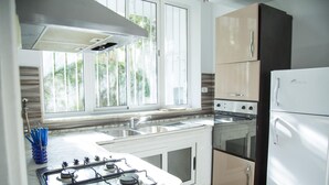 Uma cozinha moderna com fogão a gás, forno e frigorífico embutido.