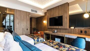 Quarto de hotel moderno com uma cama grande, uma escrivaninha e uma televisão.