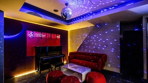 Uma área de estar moderna com um sofá vermelho, um piano e uma bola de discoteca.