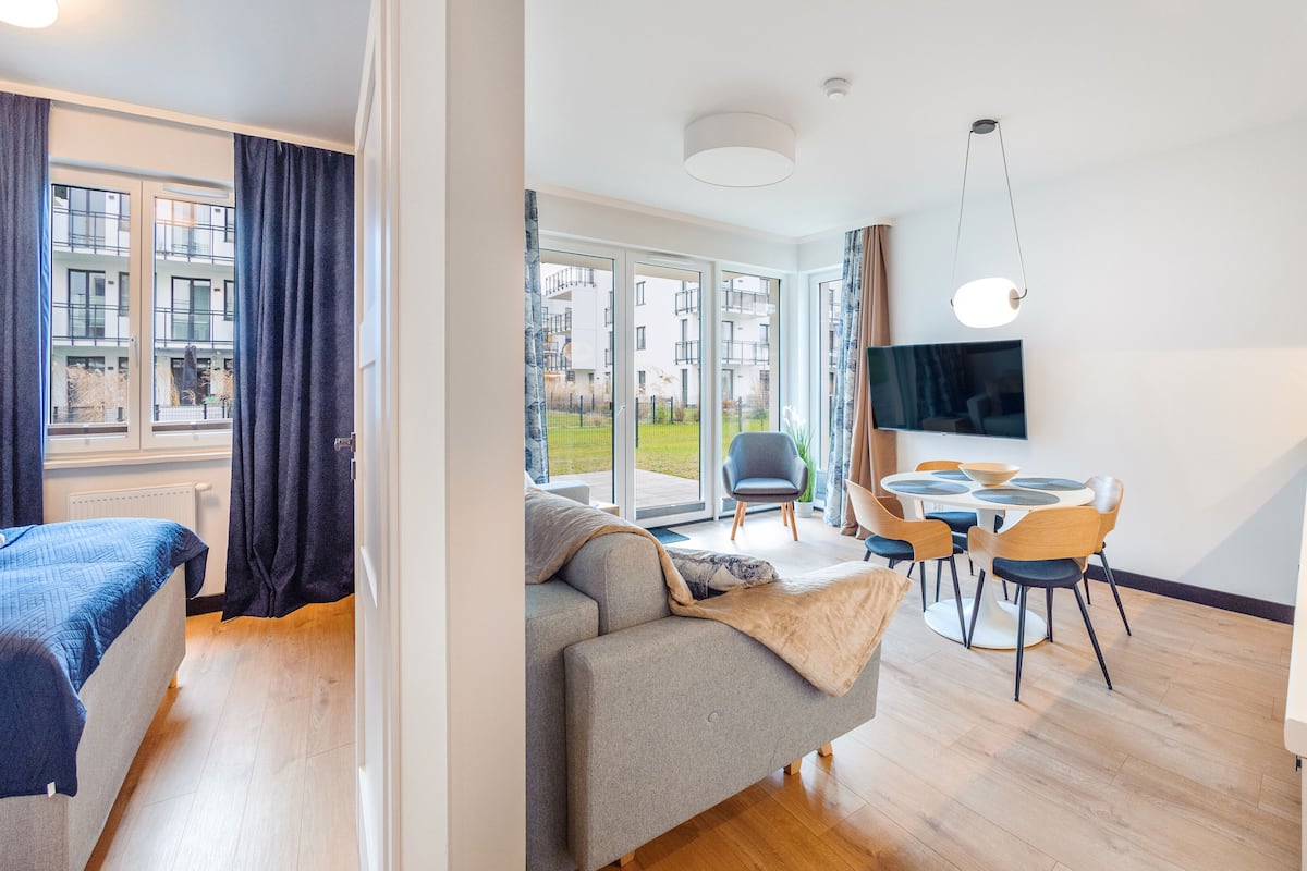 Um apartamento moderno com sala de jantar, sofá e televisão.