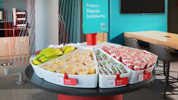 Buffet de café da manhã com seções identificadas para frutas, cereais e iogurte.