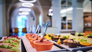 Buffet com diversos tipos de comida e uma colher numa tigela.
