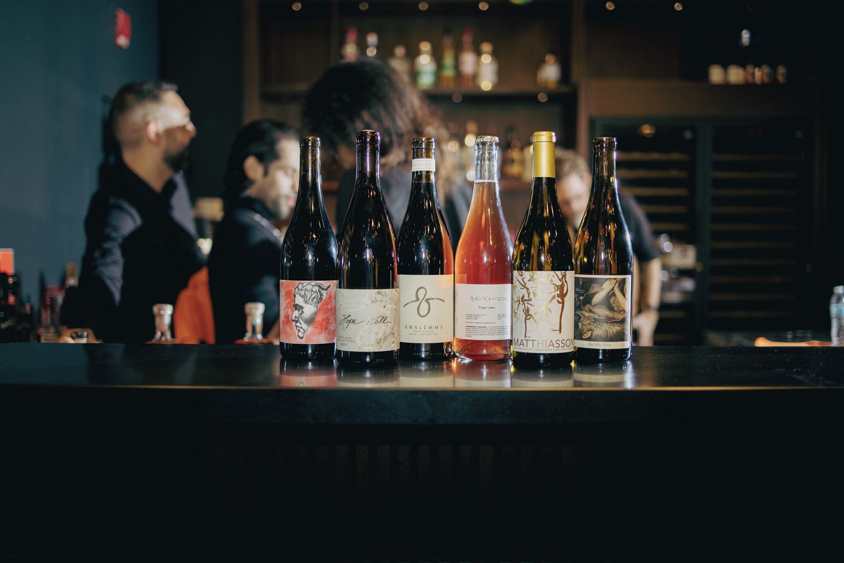 Balcão de bar com várias garrafas de vinho.