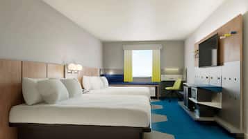 Quarto de hotel com duas camas, uma escrivaninha, uma cadeira, uma televisão e um guarda-roupa.