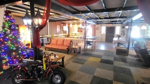 Um espaço interior acolhedor com um chão xadrez, uma árvore de Natal e uma motocicleta.