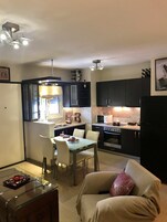 Apartamento Deluxe, 1 quarto | Sala de estar | Televisor de ecrã plano de 50 polegadas com canais por cabo, televisor 