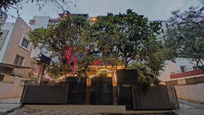 Uma árvore com luzes em frente a um edifício.