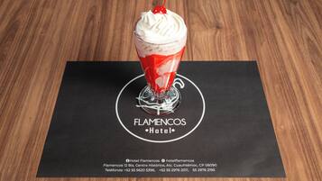 Sobremesa sobre um sousplat preto com o logotipo e informações de contato do Hotel Flamencos.