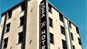 Um edifício de hotel moderno com uma placa de destaque que diz "KOZA HOTEL".