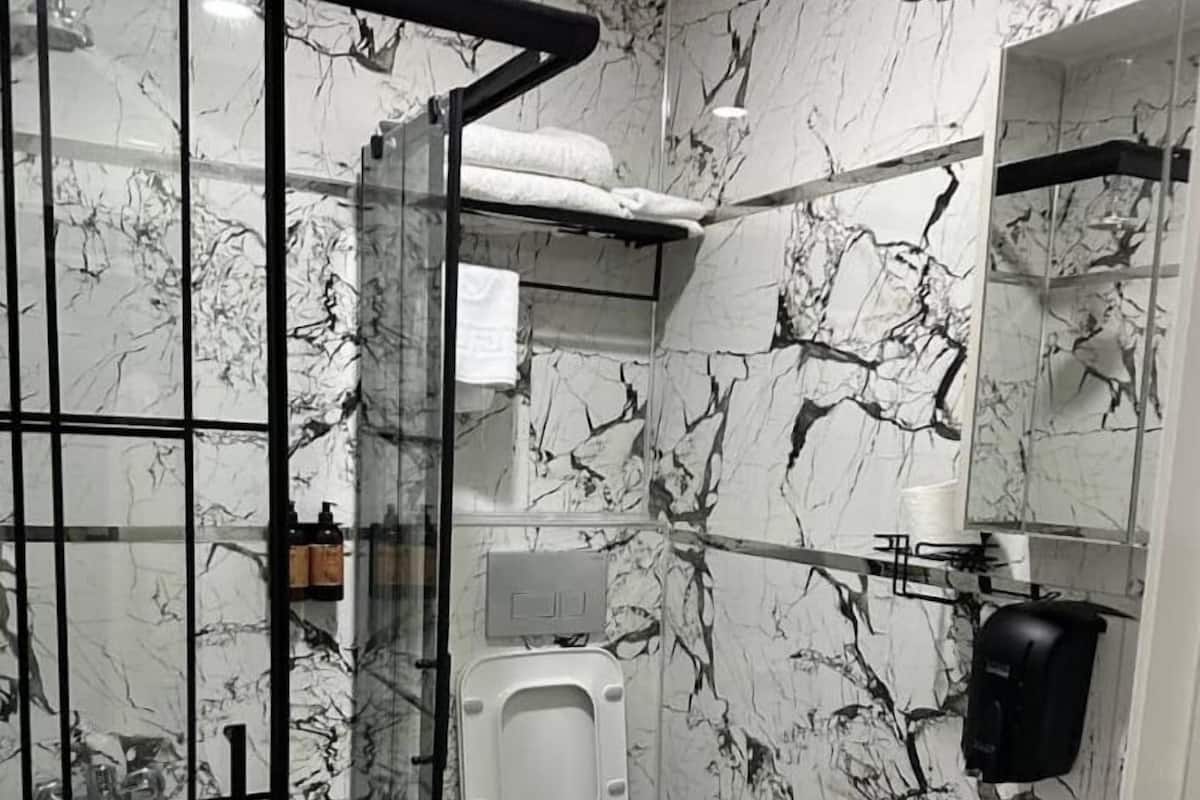 Chuveiro, secador de cabelo, chinelos, toalhas de banho