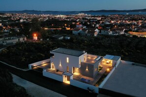 Uma casa moderna com telhado plano, vários quartos e um espaço de varanda.