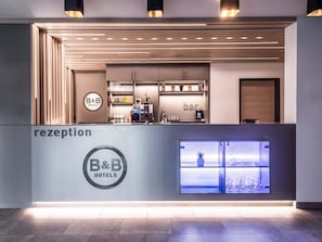 Uma área de recepção com design moderno, com balcão de atendimento, espaço de bar e exposição de copos.