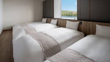 Quarto de hotel com uma janela grande, painéis de madeira e três camas.