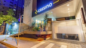 Exterior do Hotel Cassino Tower, com design moderno, destacando uma entrada imponente, uma escadaria que leva ao lobby e uma entrada por portão.