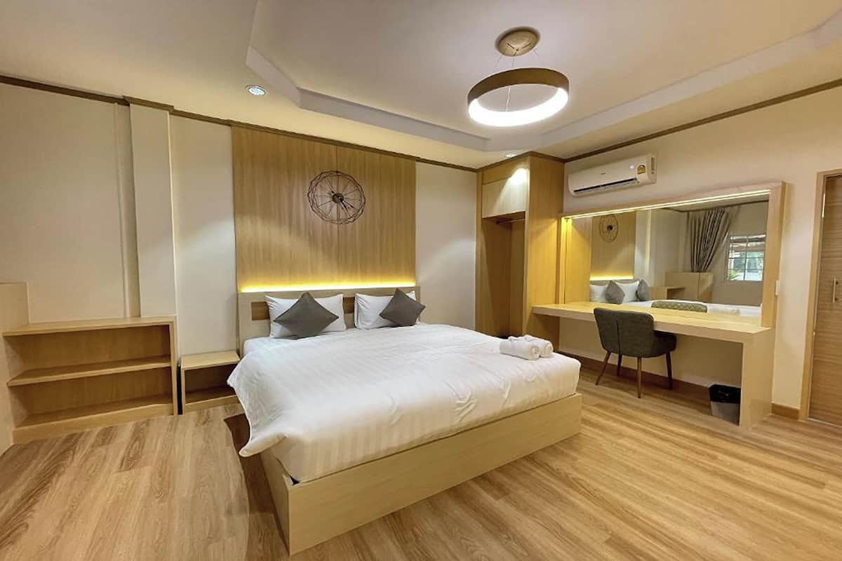 Quarto de hotel moderno com cama, escrivaninha e roupeiro embutido.
