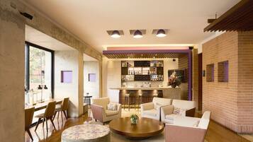 Uma sala de estar moderna com uma mesa de centro redonda, sofás e um espaço bar com prateleiras cheias de garrafas.