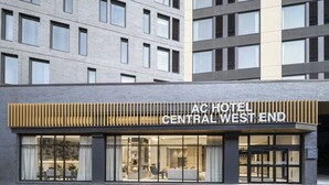 Um hotel com fachada moderna, grandes janelas e uma placa com a inscrição "AC HOTEL CENTRAL WEST END".