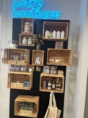 Uma boutique com estantes de madeira que exibem diversos itens, como livros, garrafas e objetos decorativos.