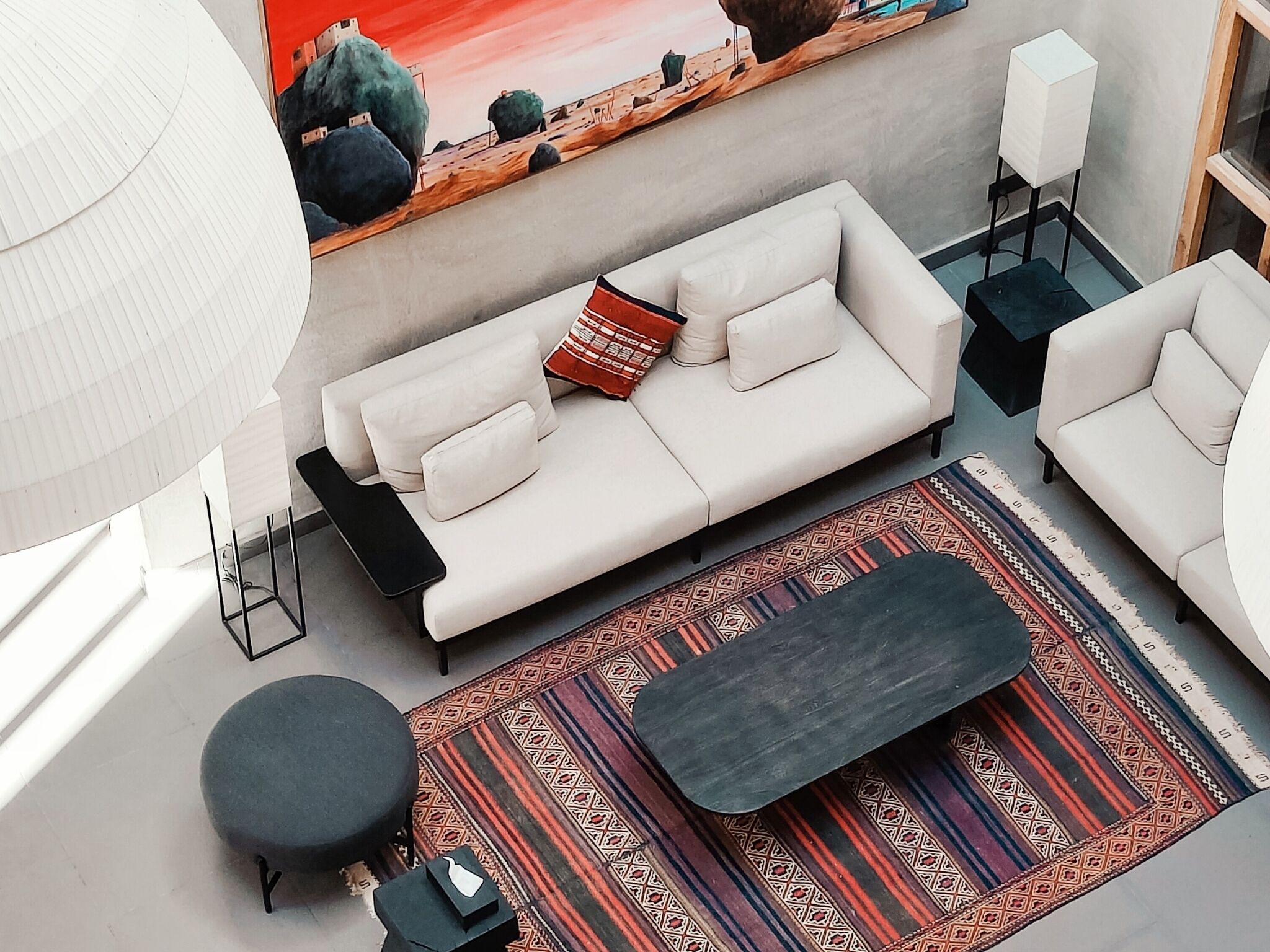 Uma sala de estar moderna com um sofá branco, um tapete estampado e uma mesa de centro.