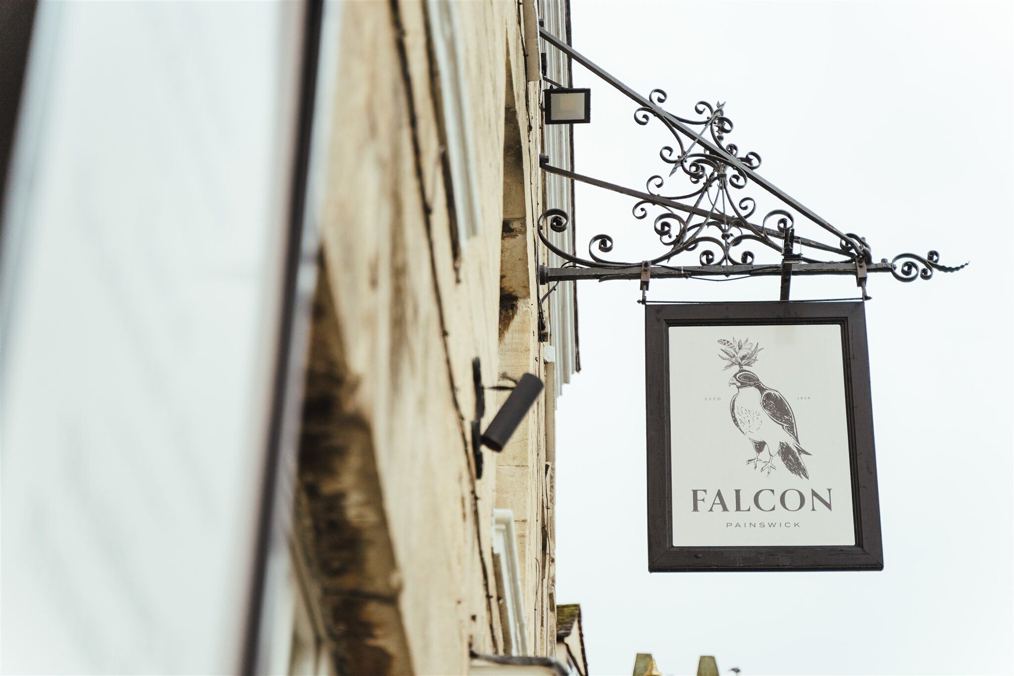 Um edifício com uma placa que diz "FALCON PAINSWICK".