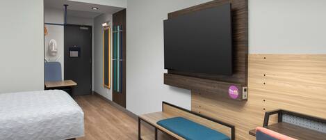Quarto de hotel com duas camas, uma televisão, uma escrivaninha e um banco.