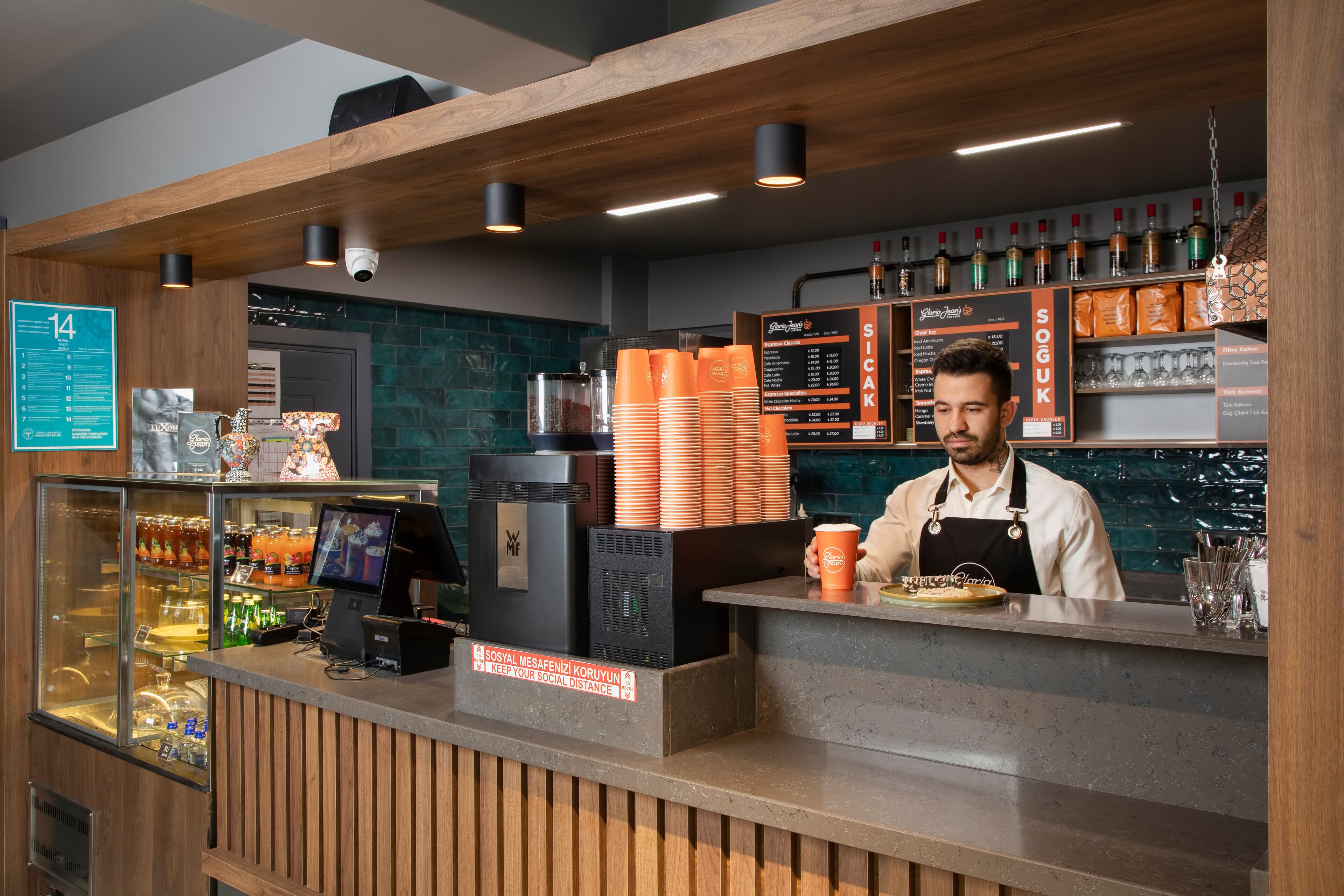 Uma área de bar com balcão, cardápio e exposição de bebidas.