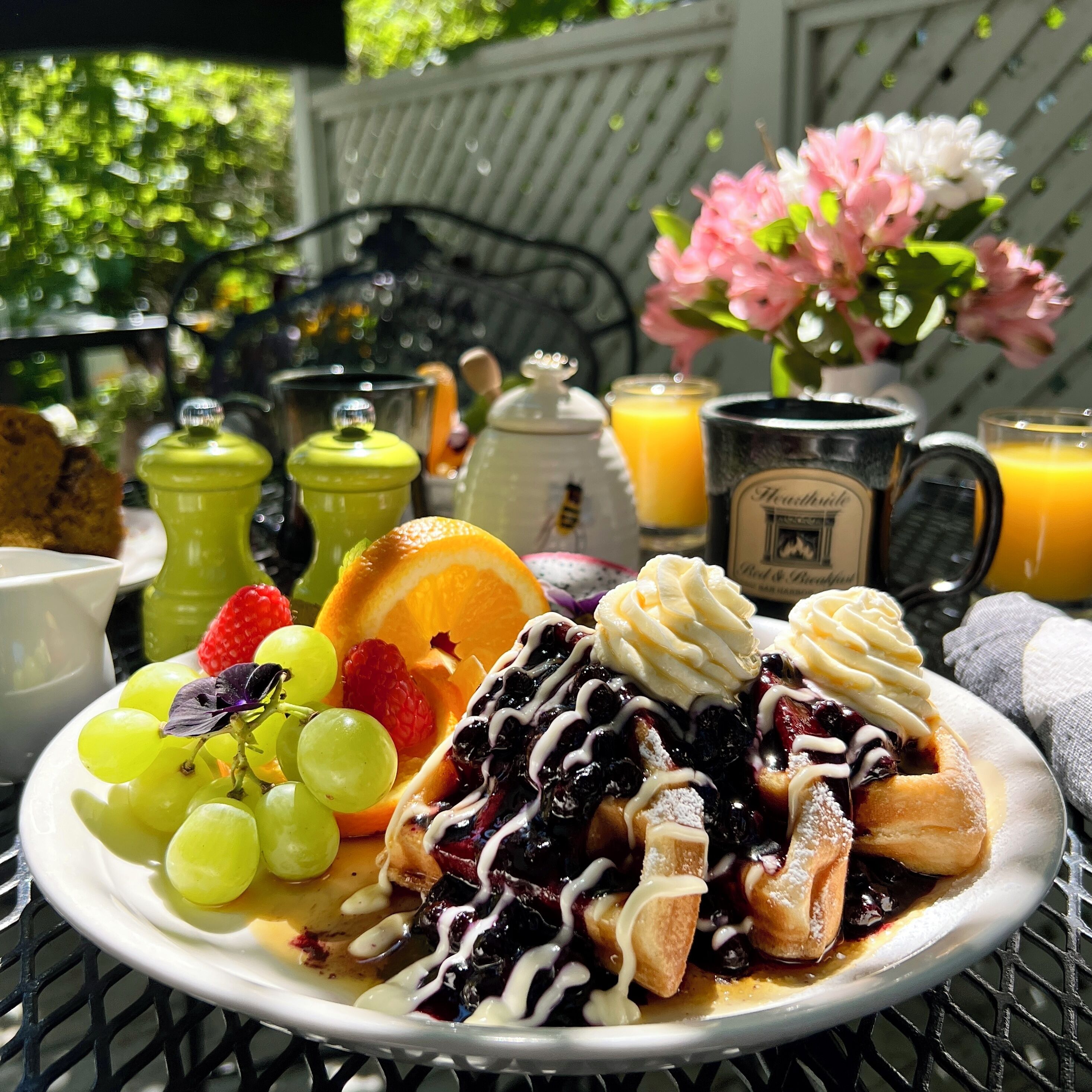 Prato de pequeno-almoço com panquecas, fruta e xarope.