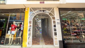 Vitrine com manequins exibindo roupas esportivas, entrada com azulejos e exposição de calçados.
