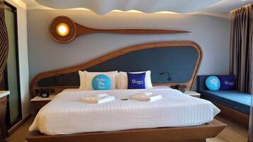 Quarto de hotel moderno com uma cama grande, cabeceira de madeira e um design de teto único.
