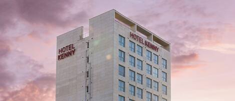 Um edifício alto de hotel com a inscrição 'HOTEL KENNY' na fachada.