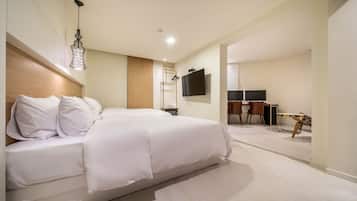 Quarto de hotel moderno com uma cama grande, uma escrivaninha e uma televisão.