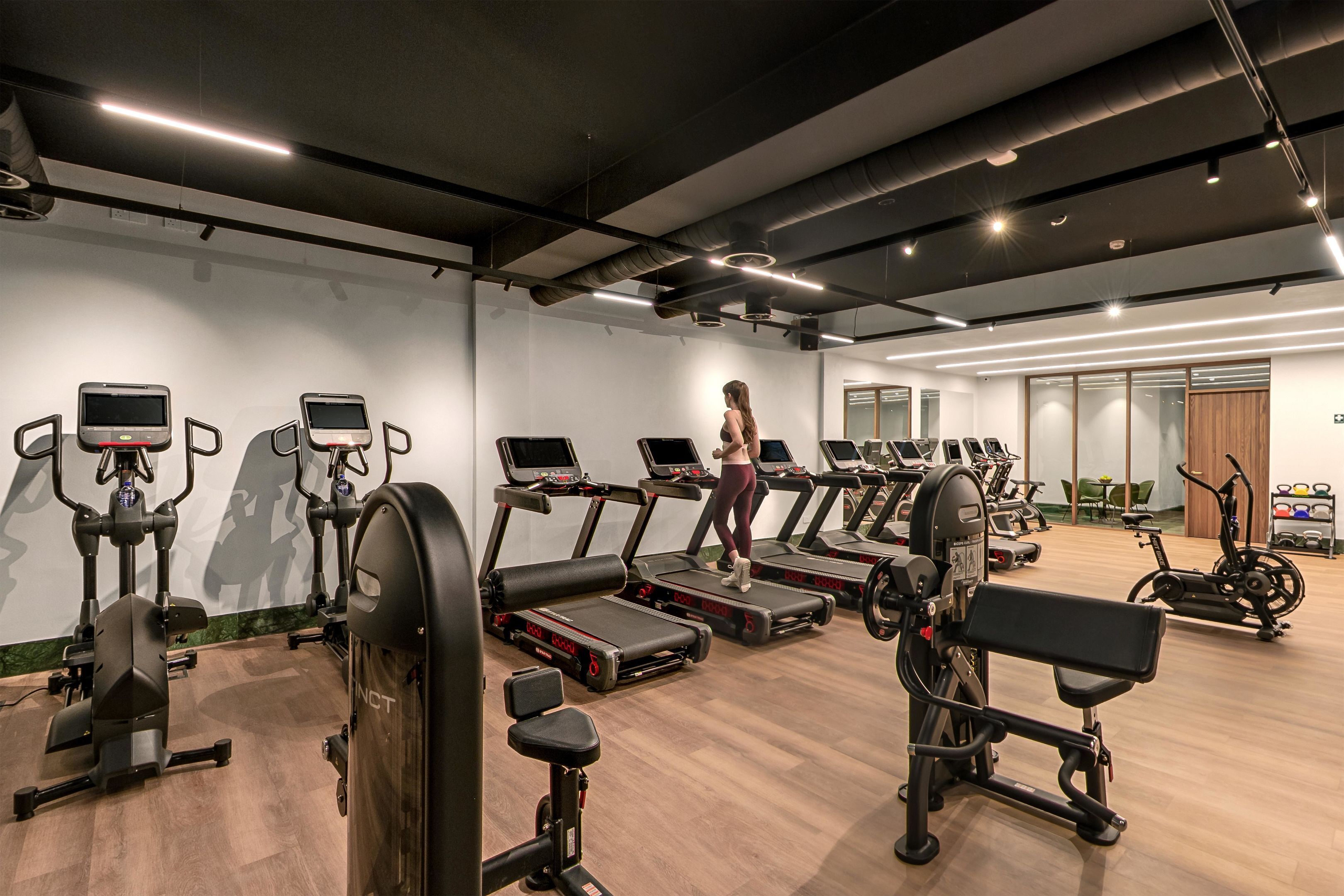 Academia com esteiras, elípticos e máquinas de musculação.