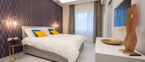 Quarto moderno com cama, mesa de cabeceira e uma escultura singular.