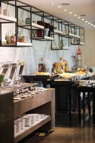 Disposição de buffet com diversas estações de serviço, incluindo variedade de alimentos e acompanhamentos.